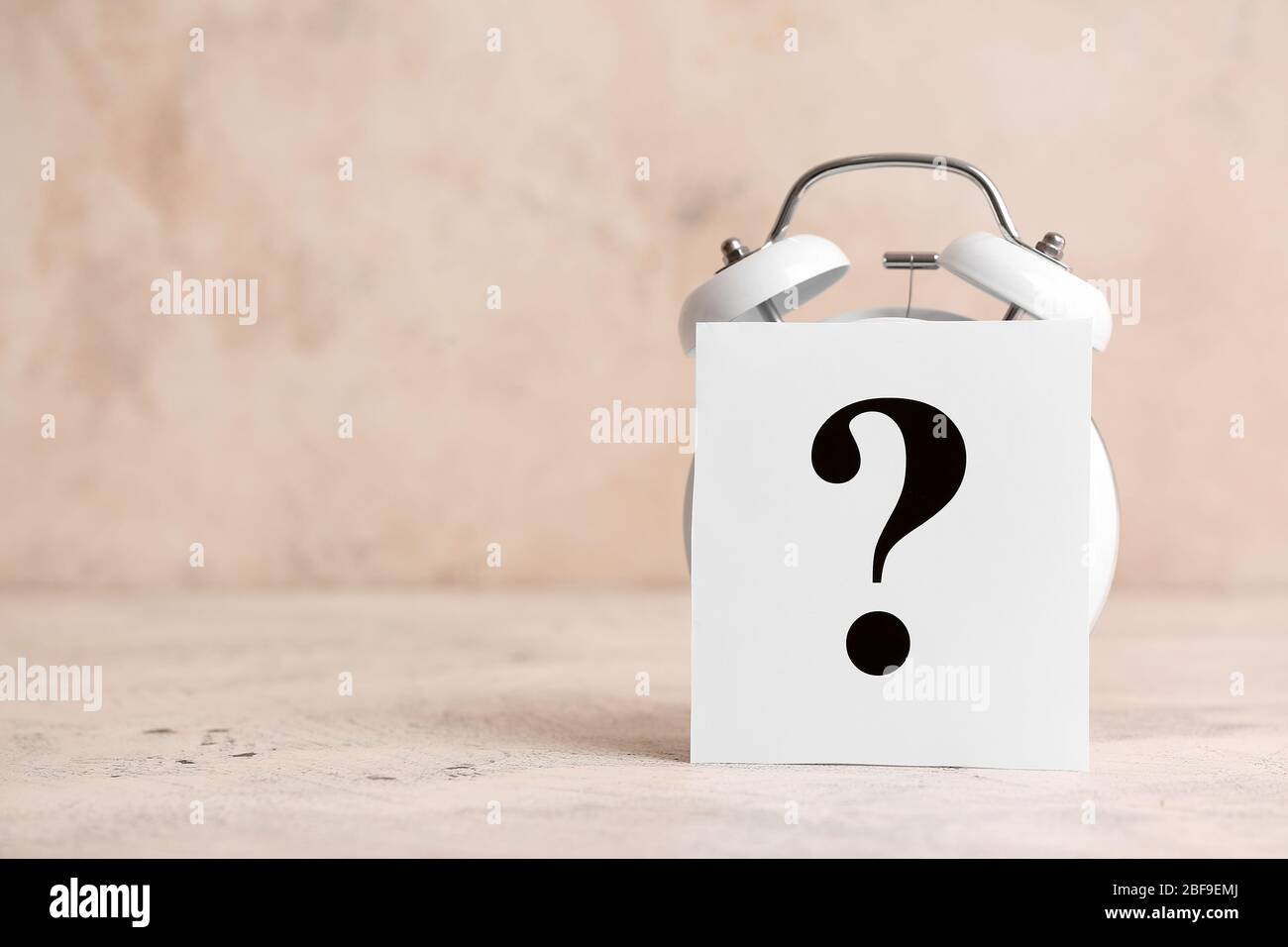 Alarm clock and paper with question mark on table. Time management ...