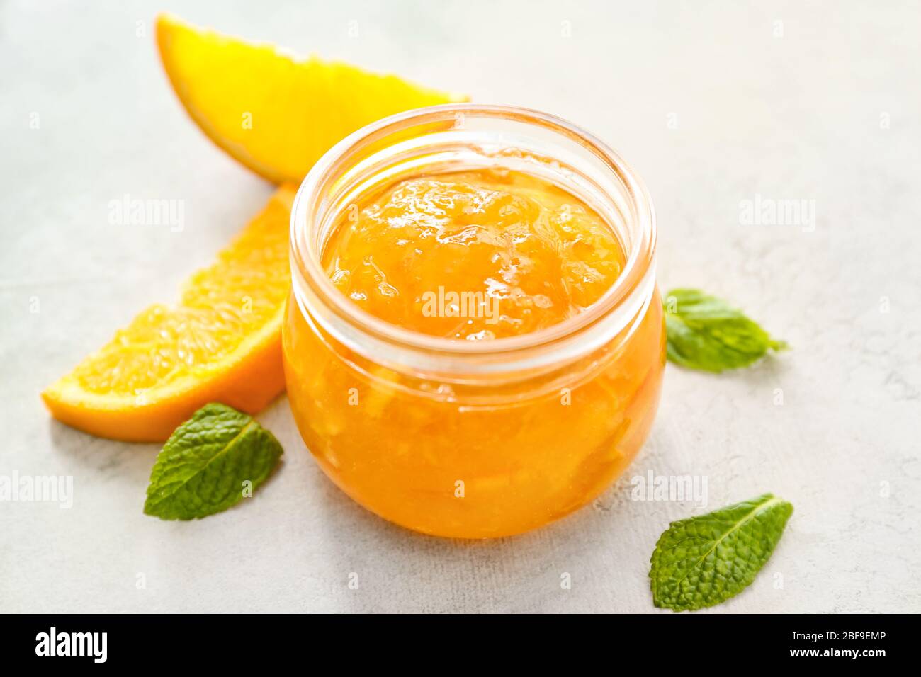 Jar of orange jam on light background Stock Photo - Alamy
