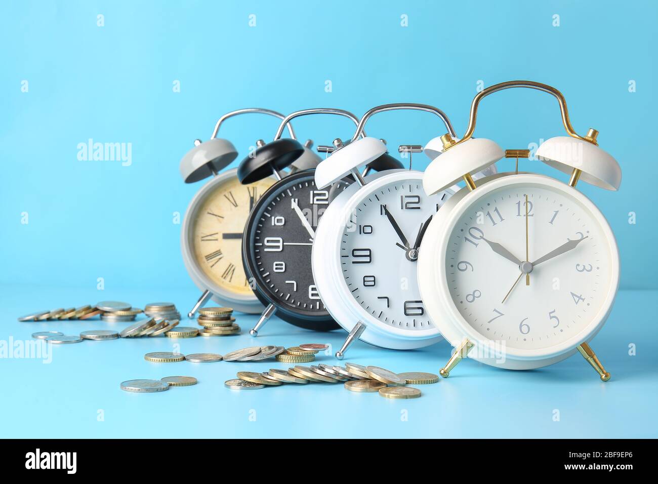 Alarm clocks and coins on color background. Time management concept ...