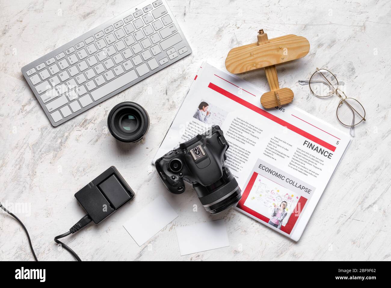 Modern photo camera with computer keyboard and newspaper on white ...