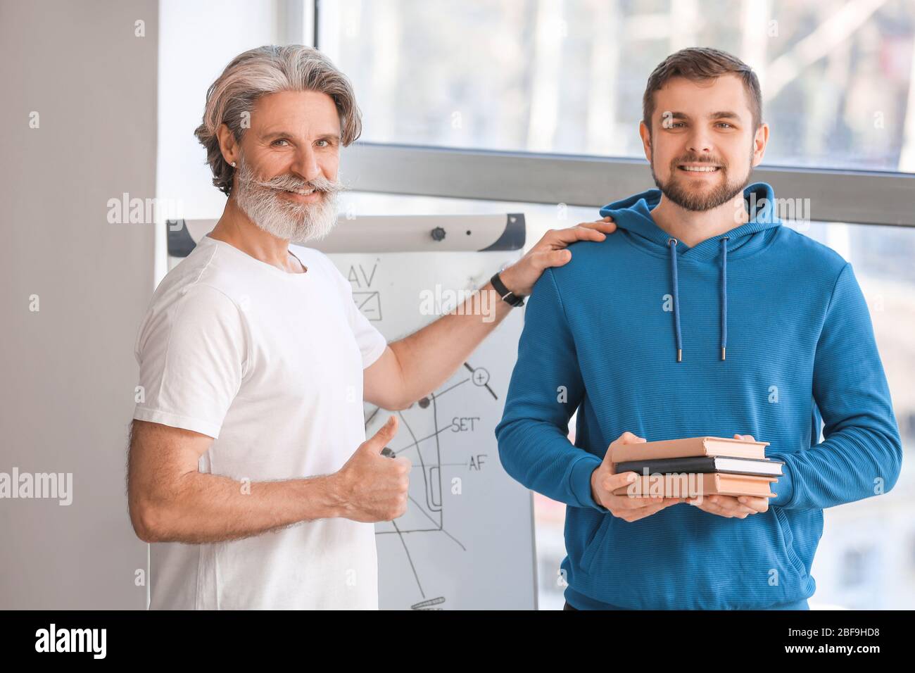 Mentor teaching young photographer in studio Stock Photo - Alamy