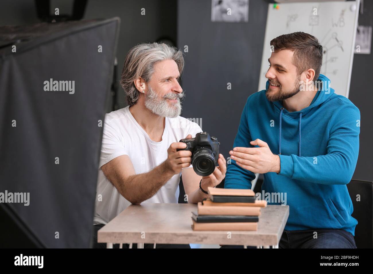 Mentor teaching young photographer in studio Stock Photo - Alamy
