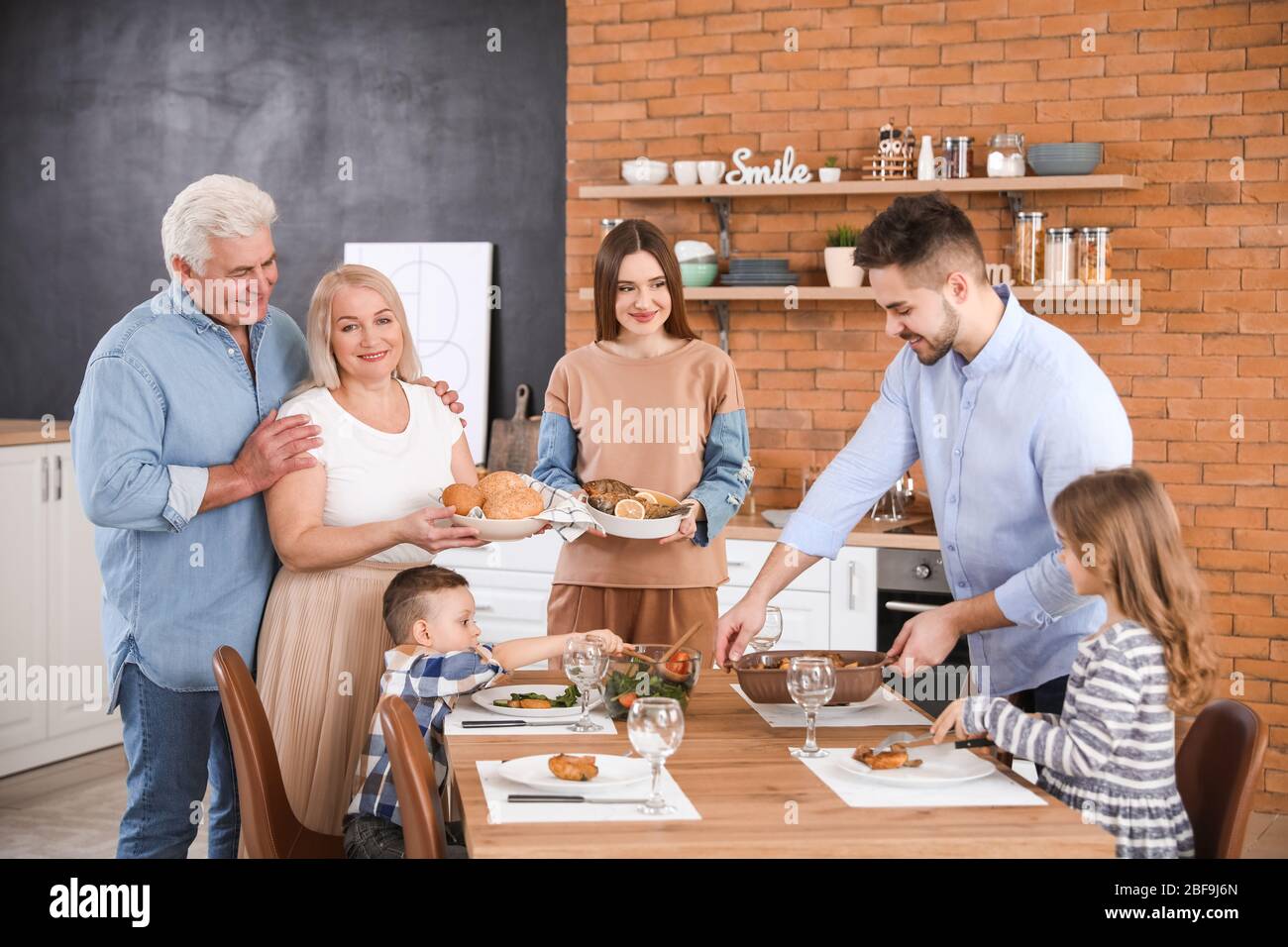 Big family having dinner together in kitchen Stock Photo - Alamy