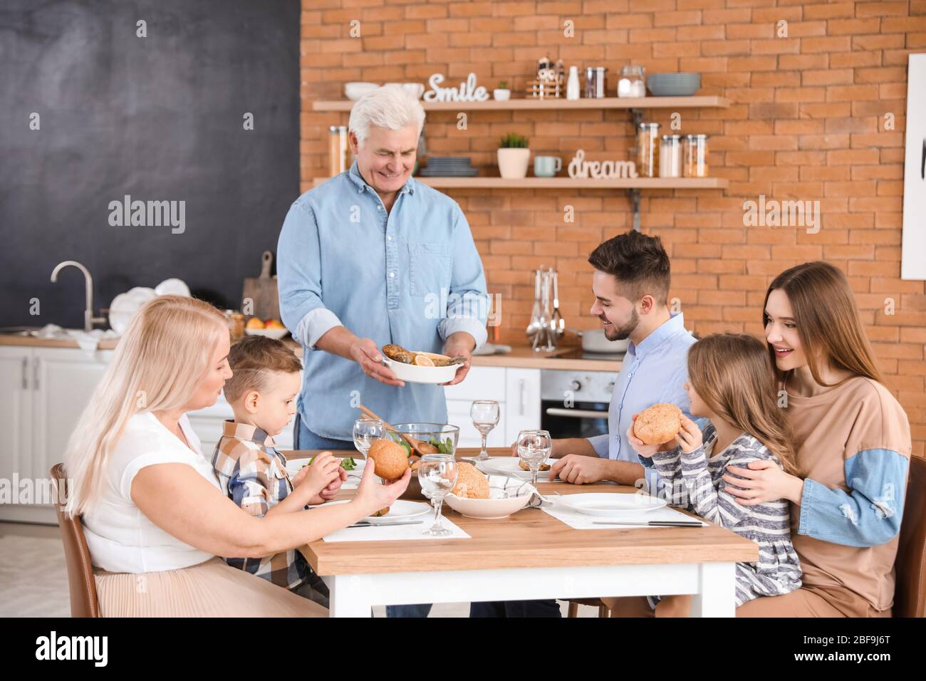 Big family having dinner together in kitchen Stock Photo - Alamy