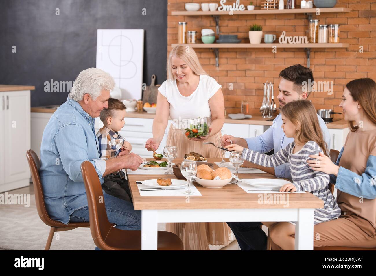Big family having dinner together in kitchen Stock Photo - Alamy