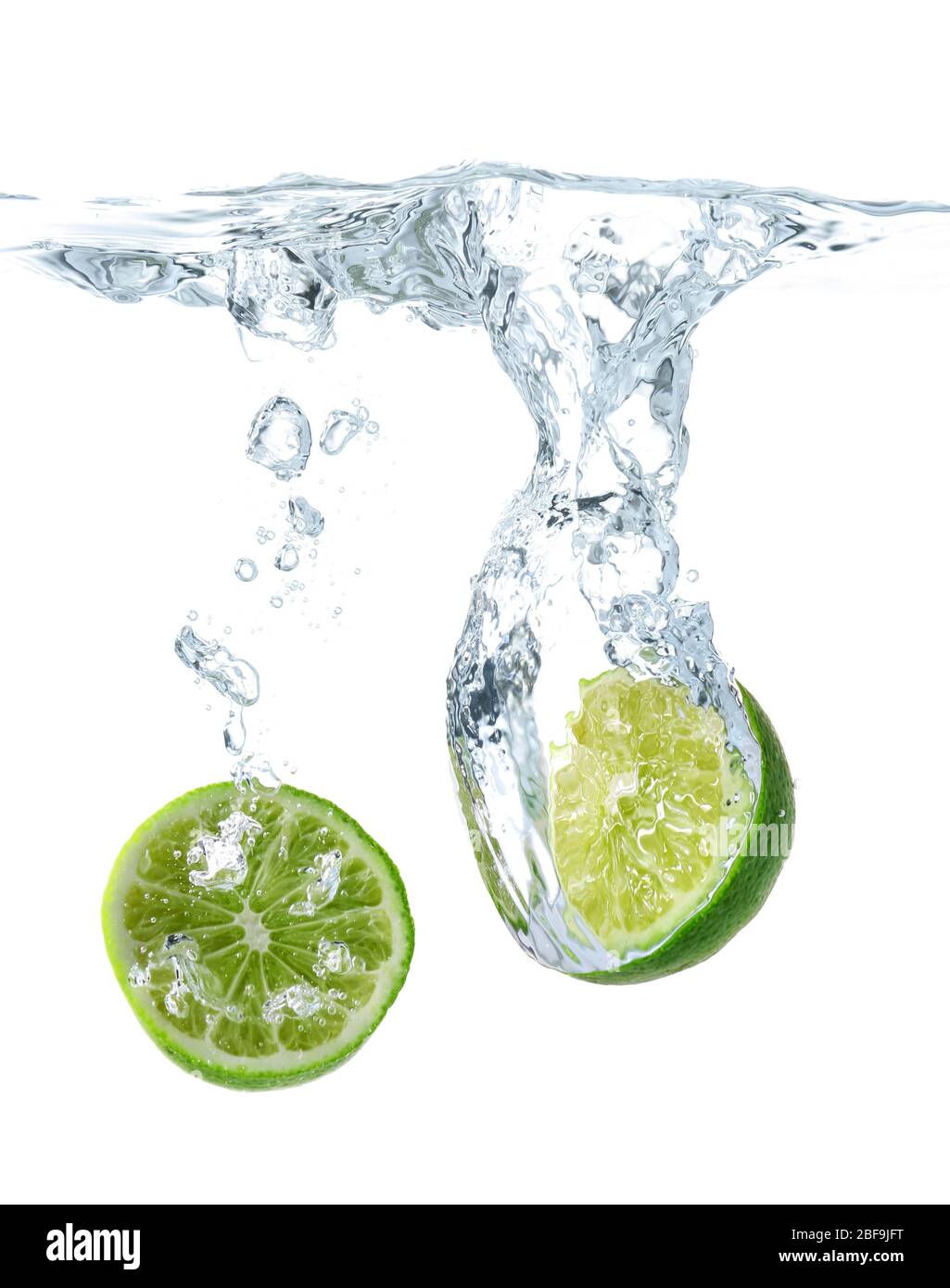 Falling of fresh cut lime into water against white background Stock ...