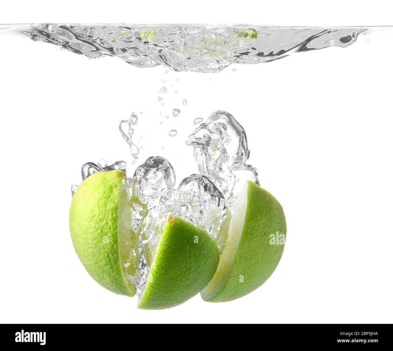 Falling of fresh cut lime into water against white background Stock ...
