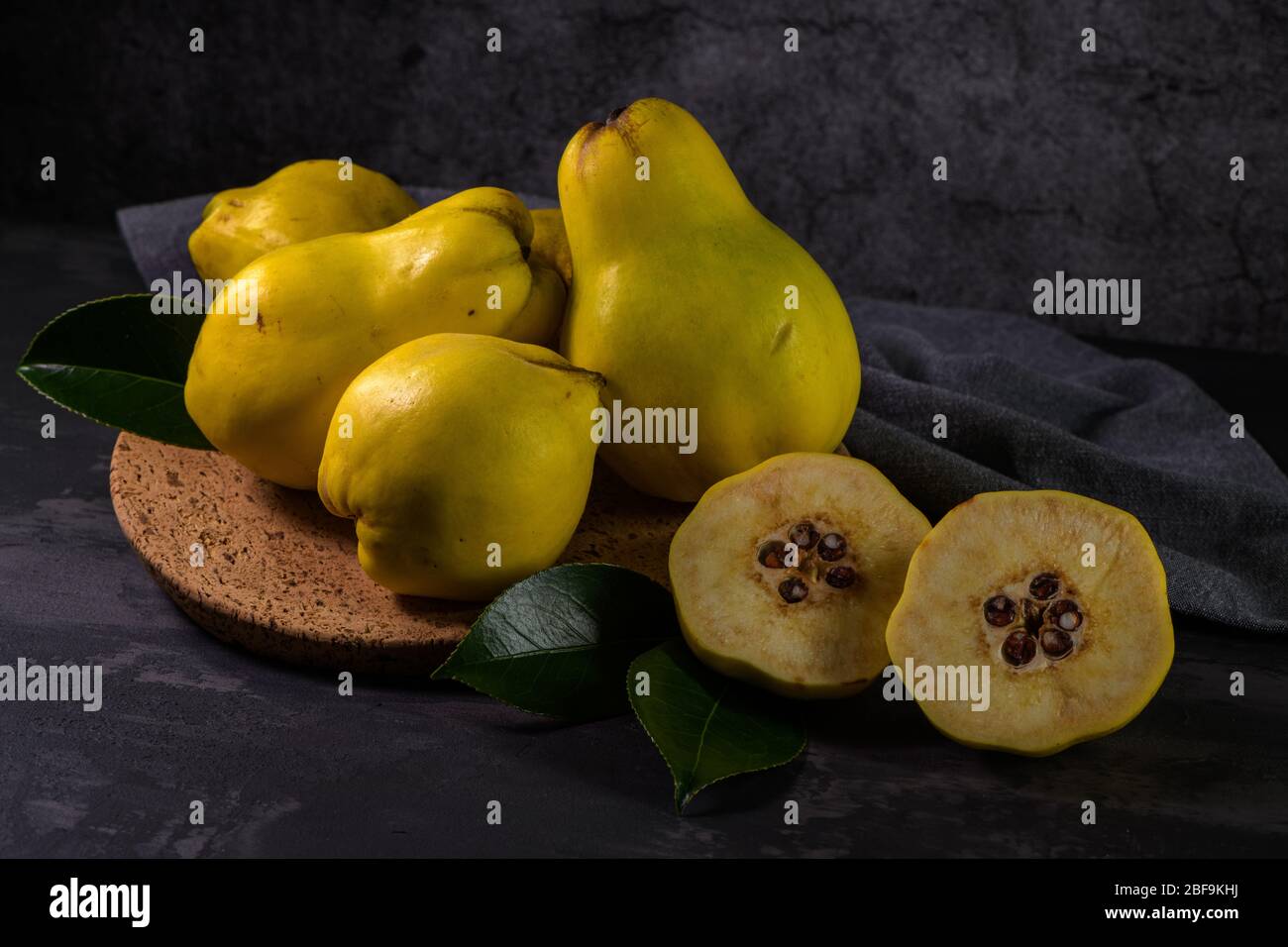 Ripe yellow quinces or queen apple fruits and sliced quince halves with ...