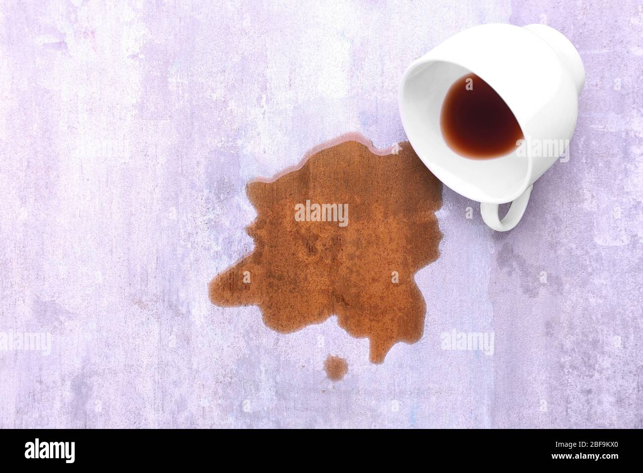 Overturned cup and spilled coffee on table Stock Photo - Alamy