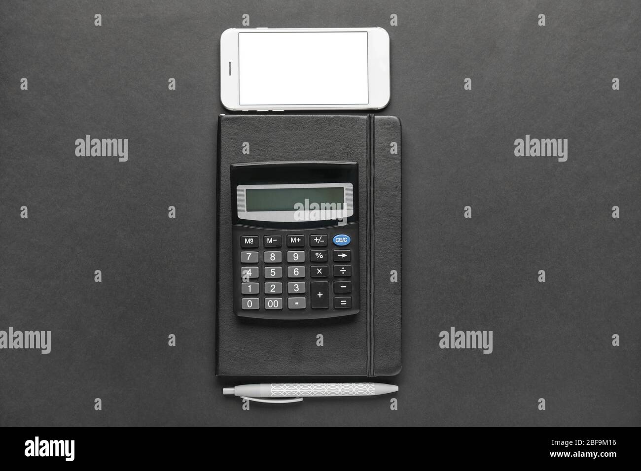 Calculator with stationery and mobile phone on dark background Stock ...