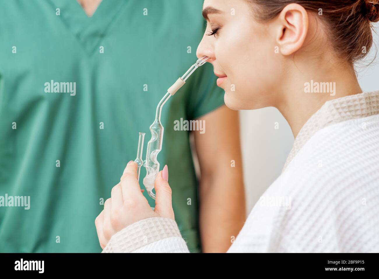 Woman receiving nasal inhalation in nose with essential oil in spa ...