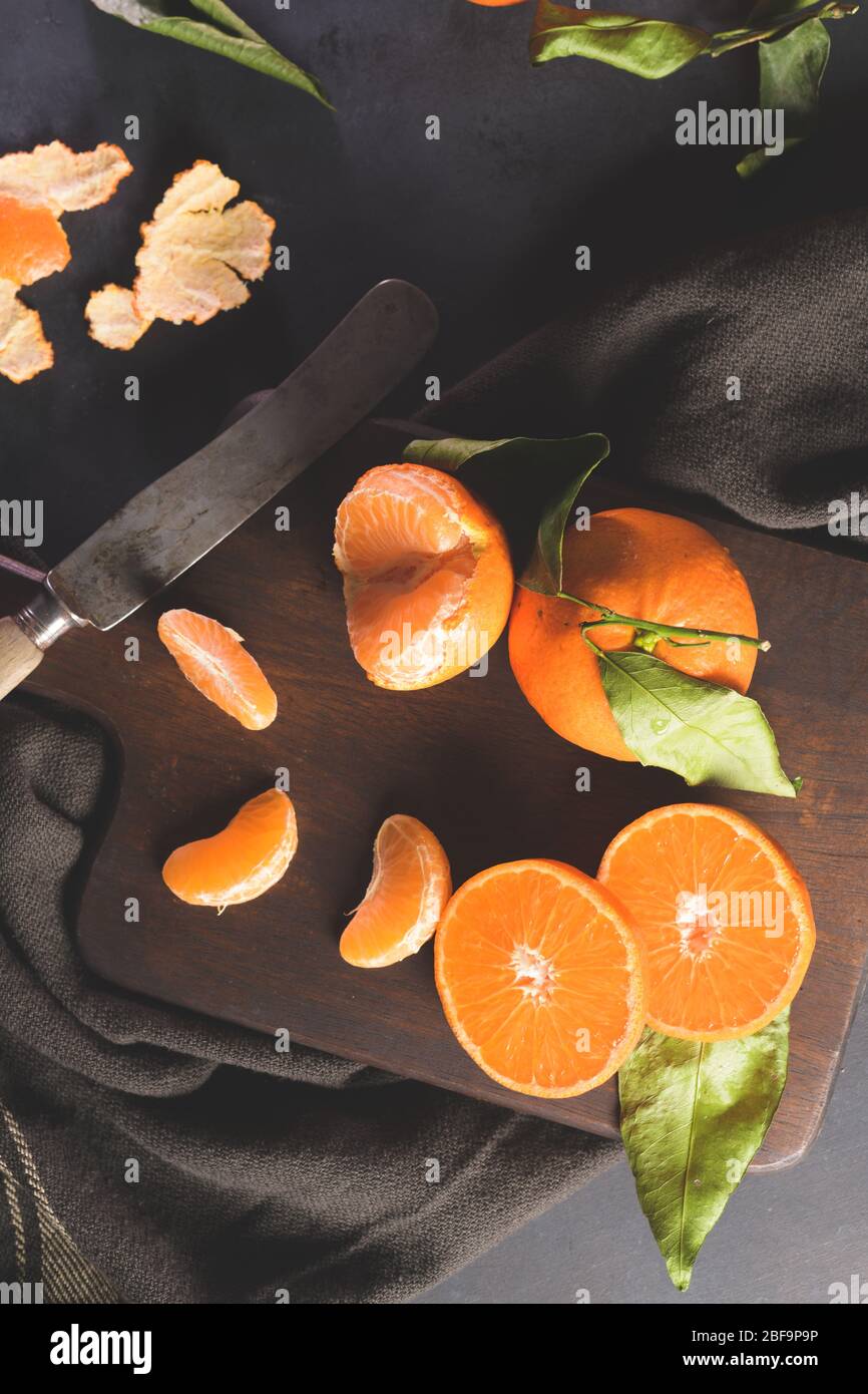 Fresh mandarin oranges or tangerines with leaves on textured dark ...