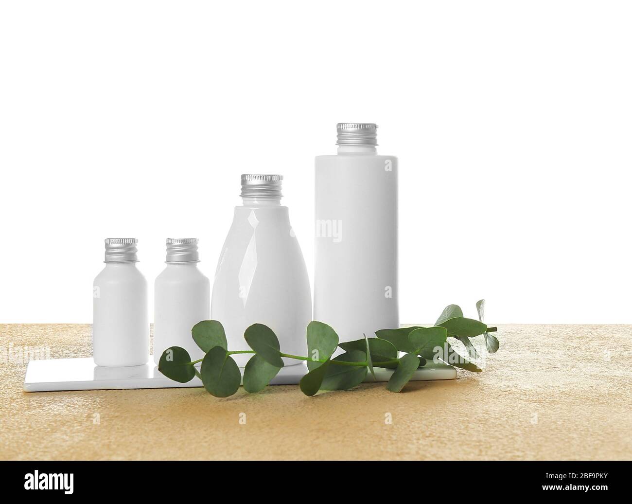 Bottles of shampoo on table against white background Stock Photo - Alamy