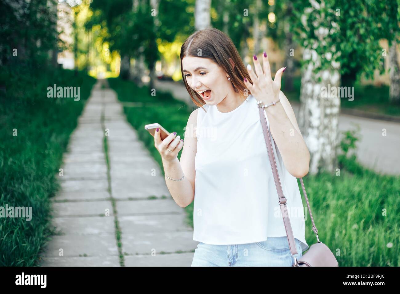 Angry modern beautiful woman screaming down her mobile phone in slow ...