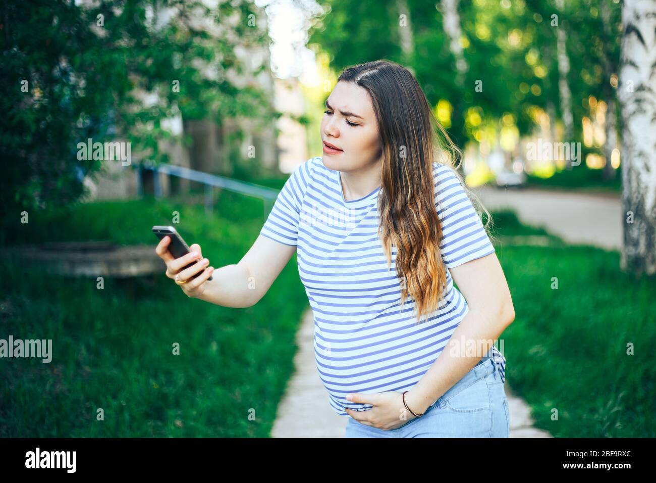 Pregnant woman with contractions feeling pain calling ambulance with ...