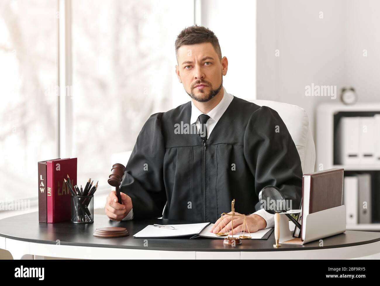 Male judge working at table in office Stock Photo - Alamy