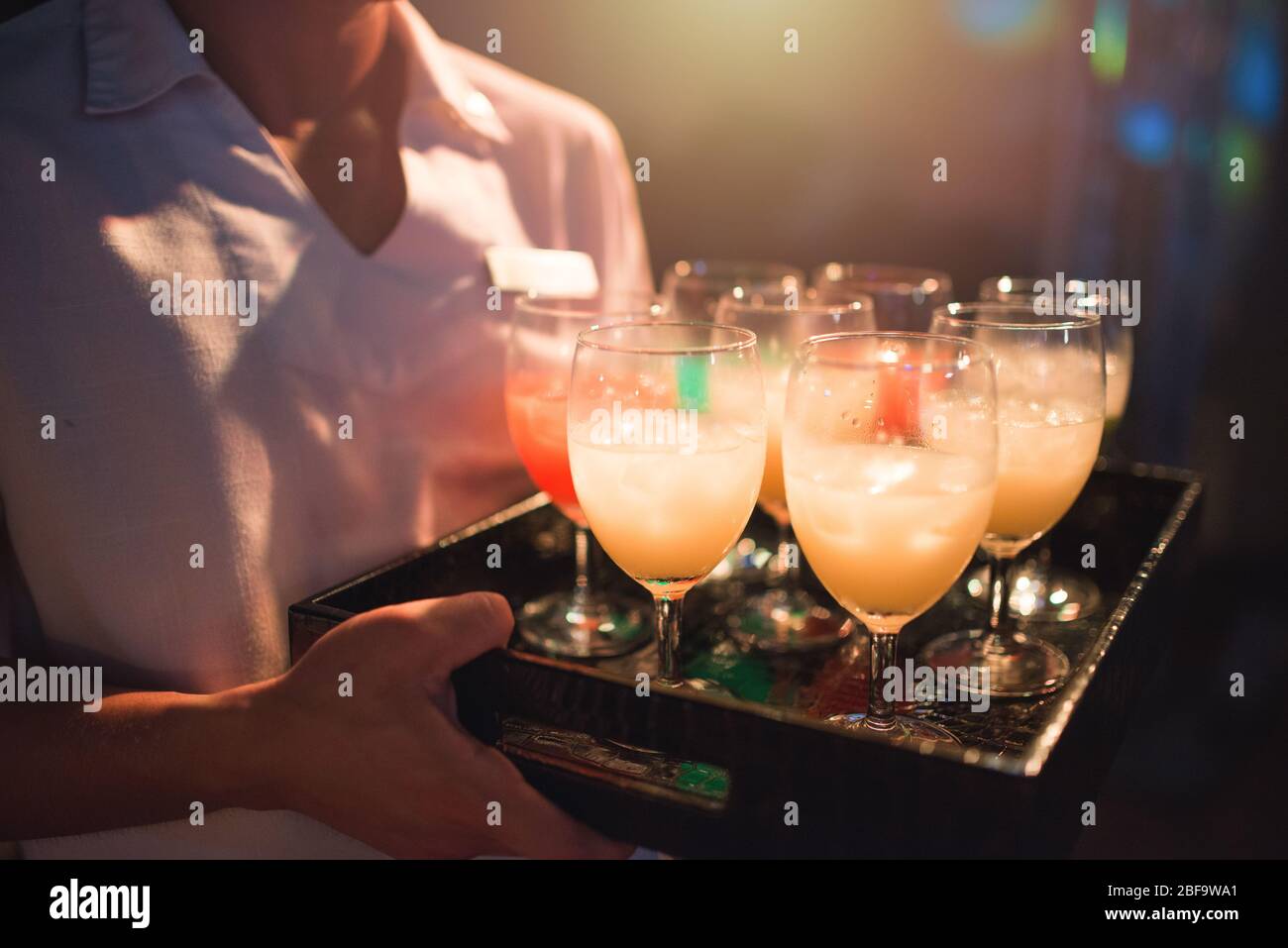Waitress carry tray of softdrink welcome drink glasses for welcome new ...