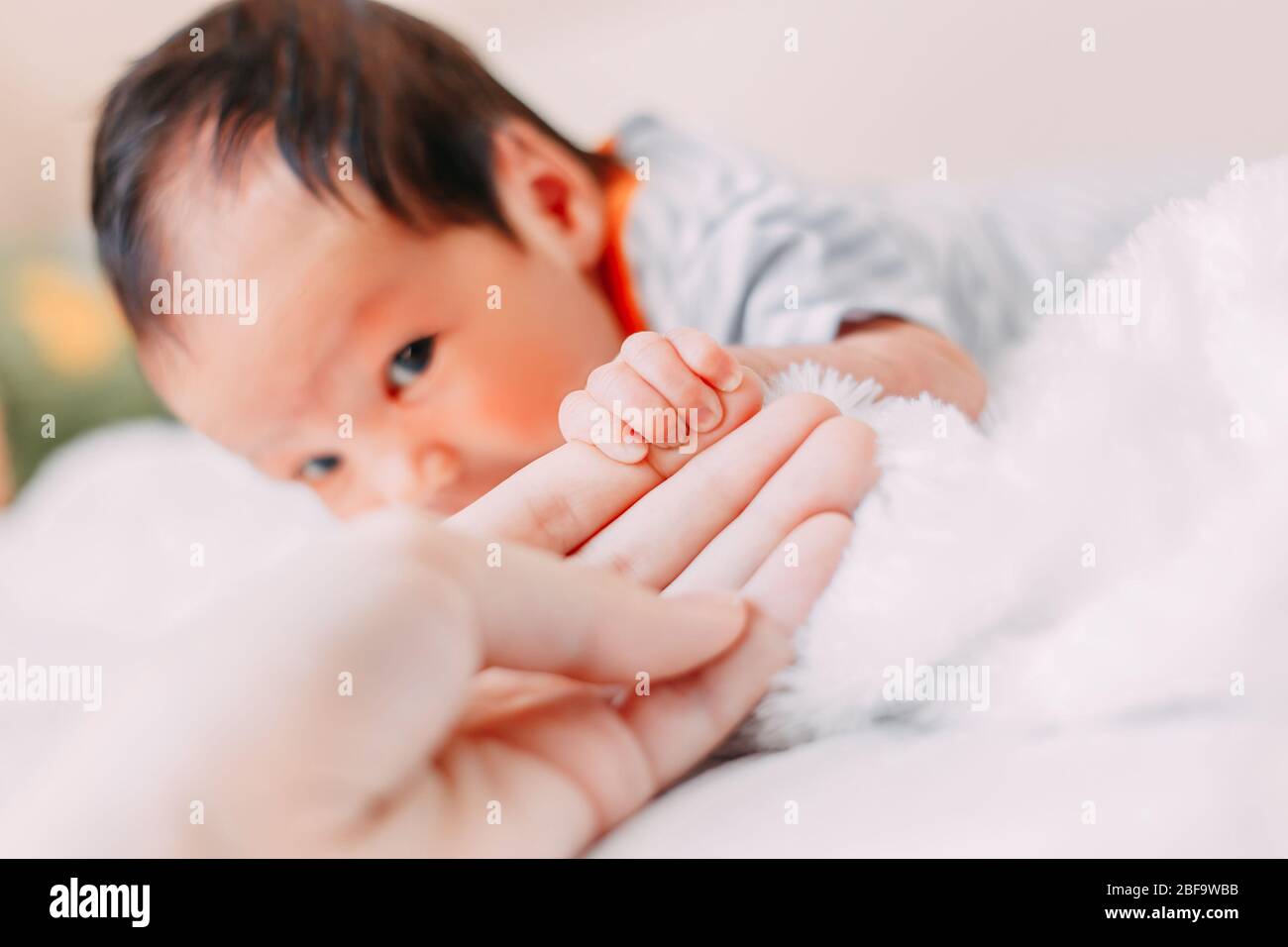 Close-up shot of baby's little cute hand reaching for mother's loving ...