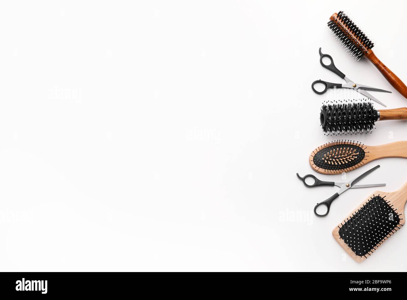 Hair brushes with scissors on white background Stock Photo - Alamy