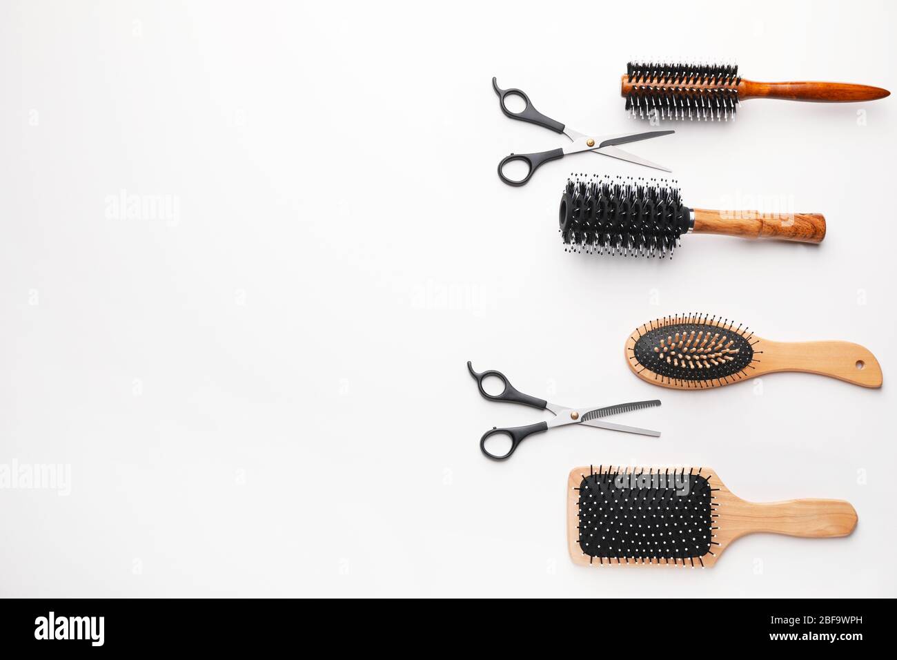 Hair brushes with scissors on white background Stock Photo - Alamy