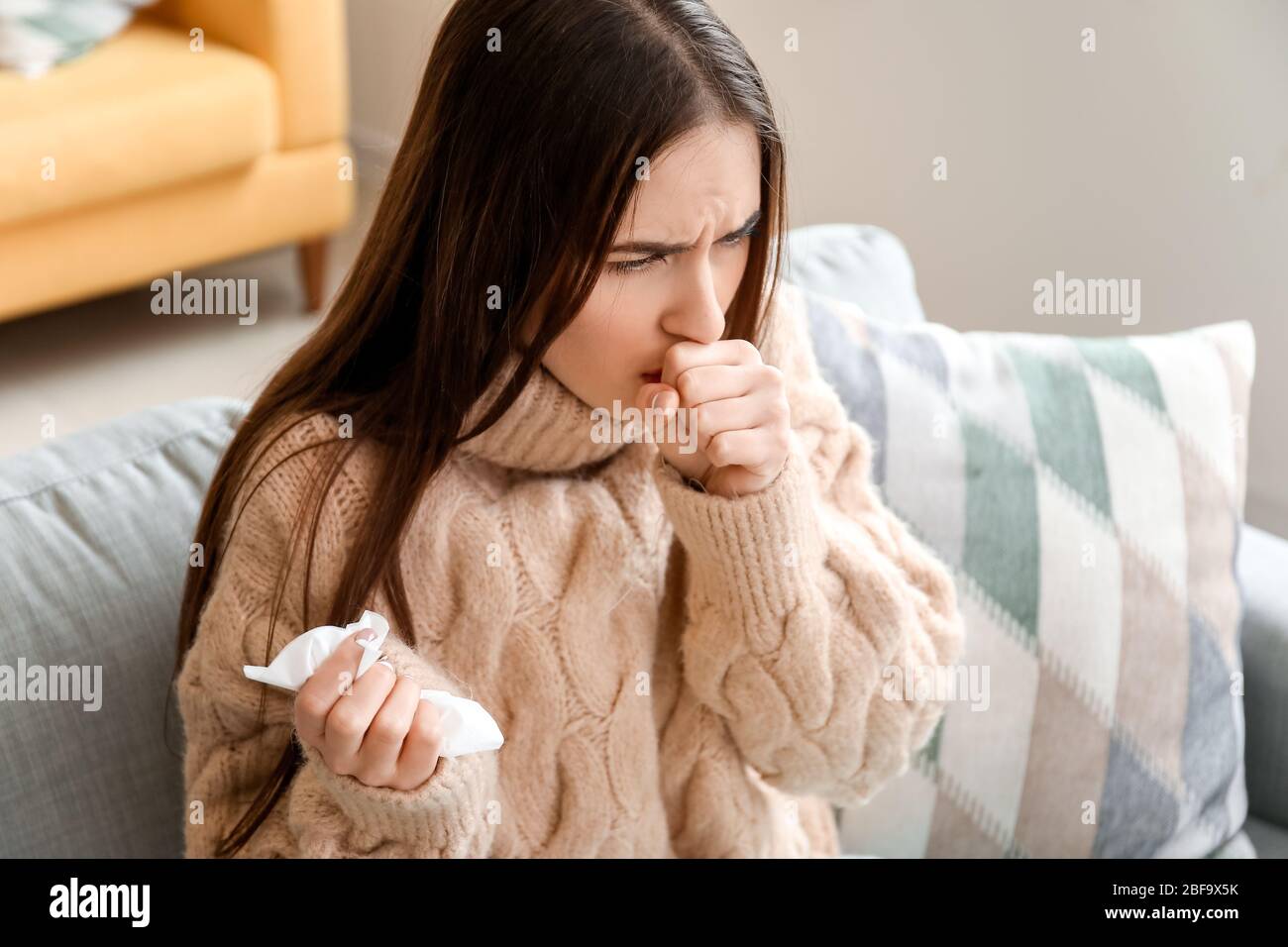 Coughing young woman at home Stock Photo - Alamy