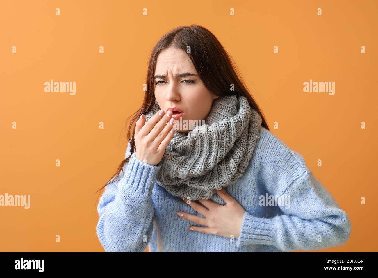 Coughing young woman on color background Stock Photo - Alamy