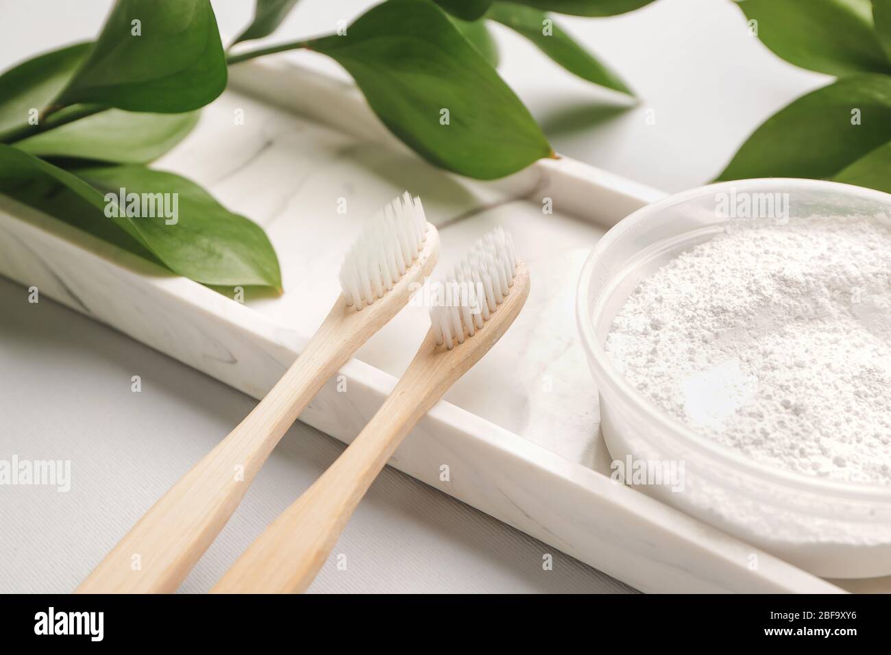 Wooden tooth brushes with toothpaste powder on light background Stock ...