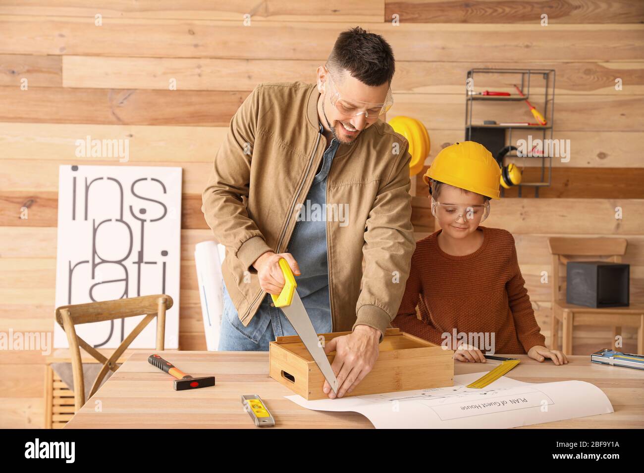 Little son helping his father in carpenter's workshop Stock Photo - Alamy