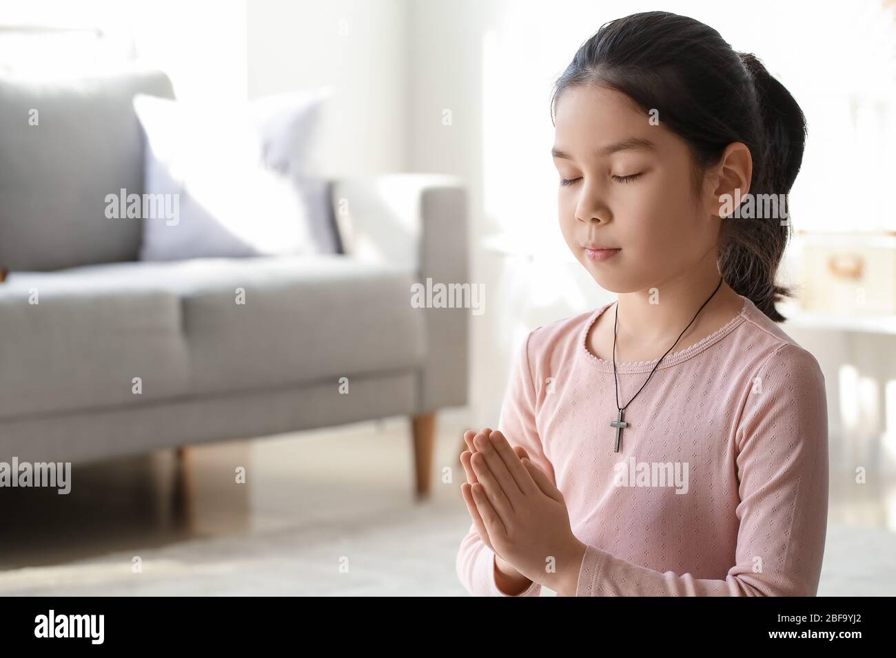Cute little Asian girl praying at home Stock Photo - Alamy