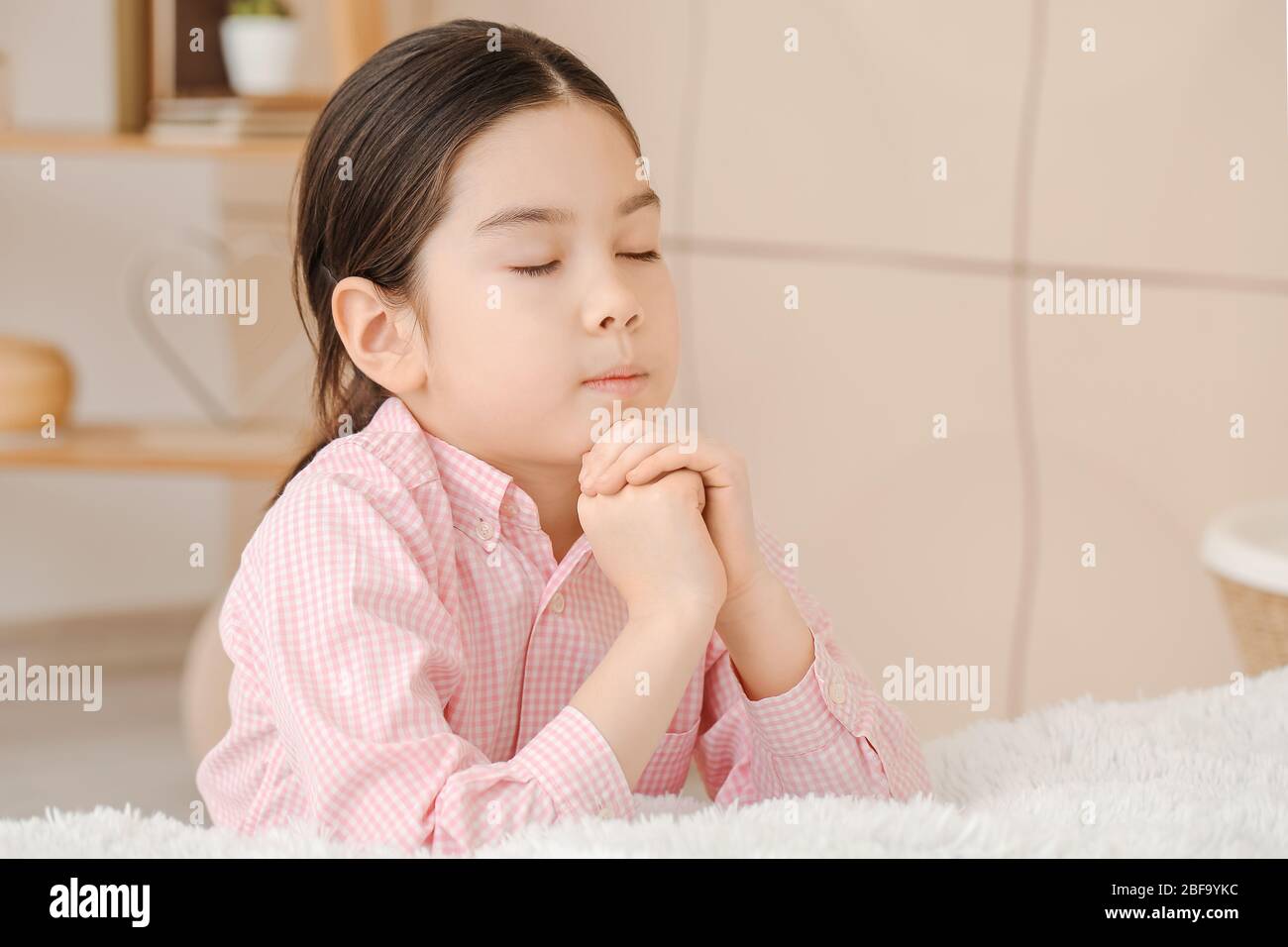 Cute little Asian girl praying at home Stock Photo - Alamy