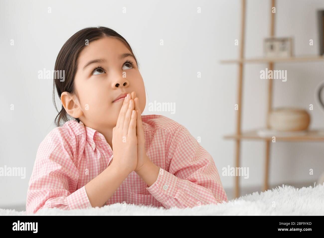 Cute little Asian girl praying at home Stock Photo - Alamy