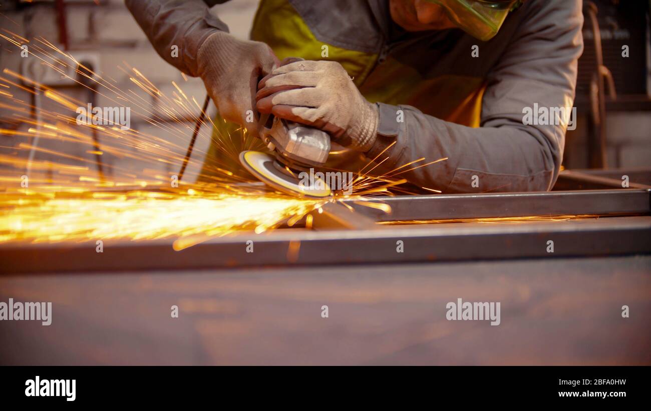 Grinding the seams of an iron frame. Mid shot Stock Photo - Alamy