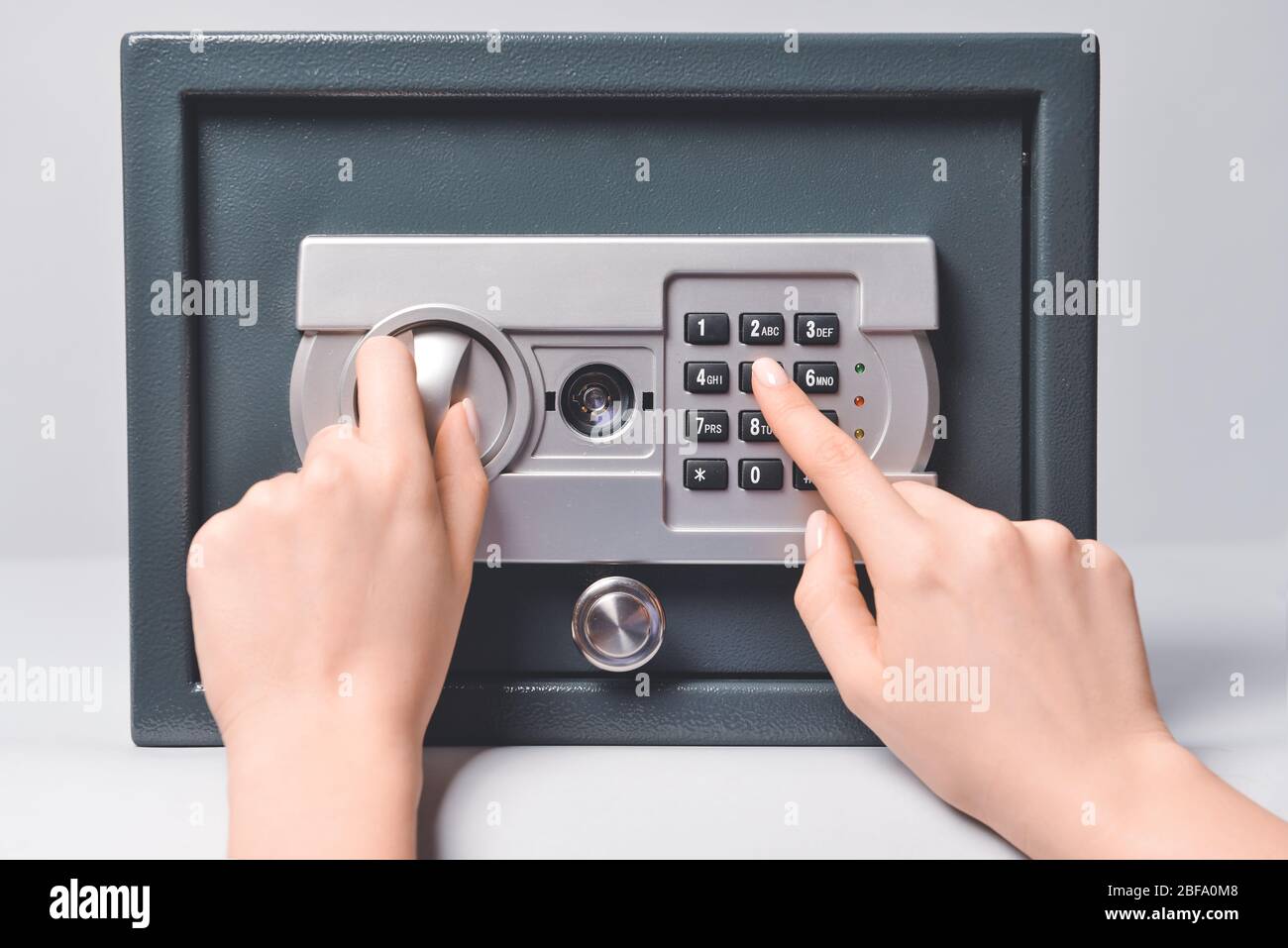 Woman opening safe box on light background Stock Photo - Alamy