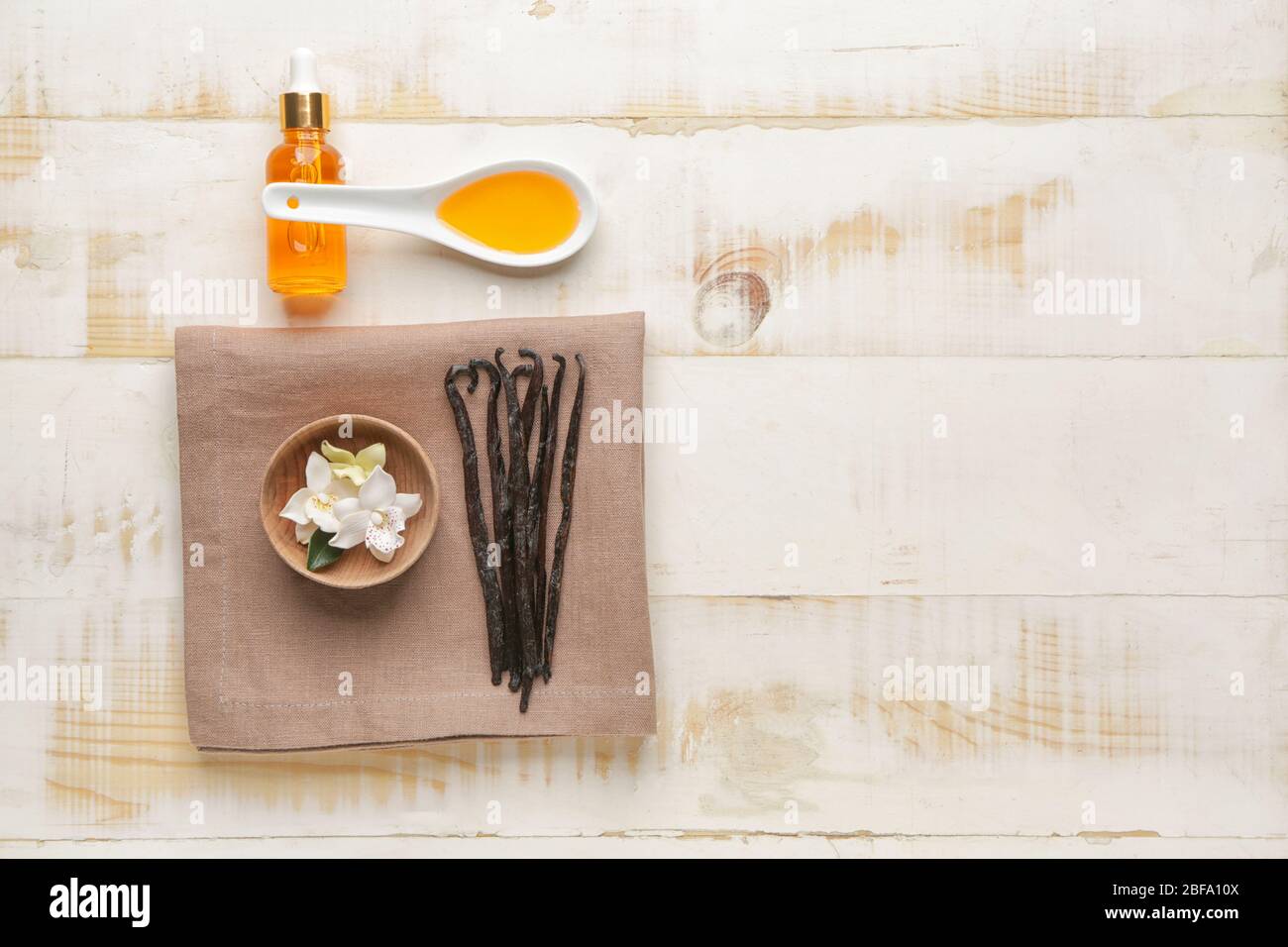 Composition with vanilla sticks and extract on wooden background Stock ...