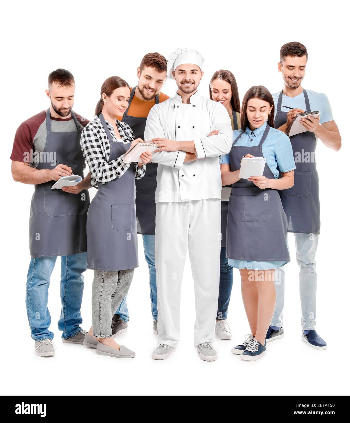 Male chef with participants of cooking classes on white background ...