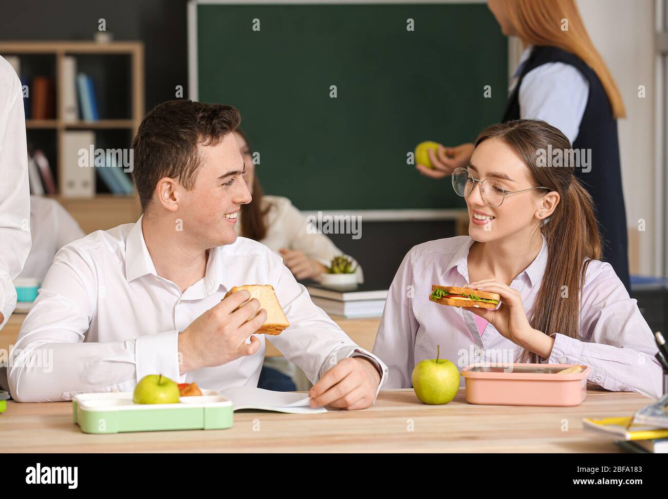 Pupils having lunch in classroom Stock Photo - Alamy