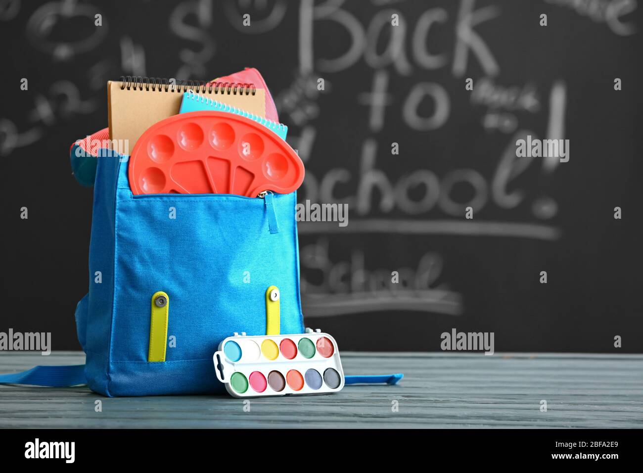 School backpack on table in classroom Stock Photo - Alamy