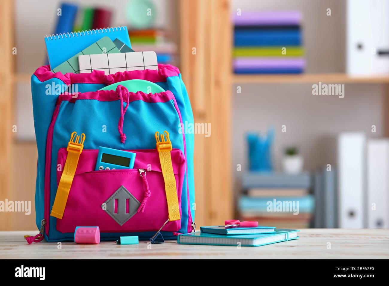 School backpack on table in classroom Stock Photo - Alamy