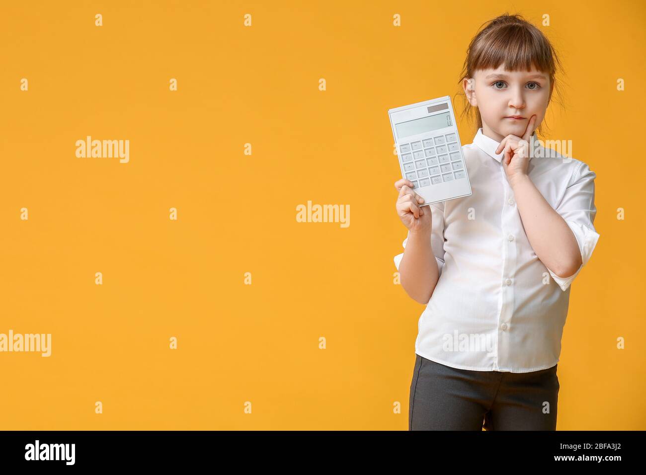 Little girl with calculator on color background Stock Photo - Alamy