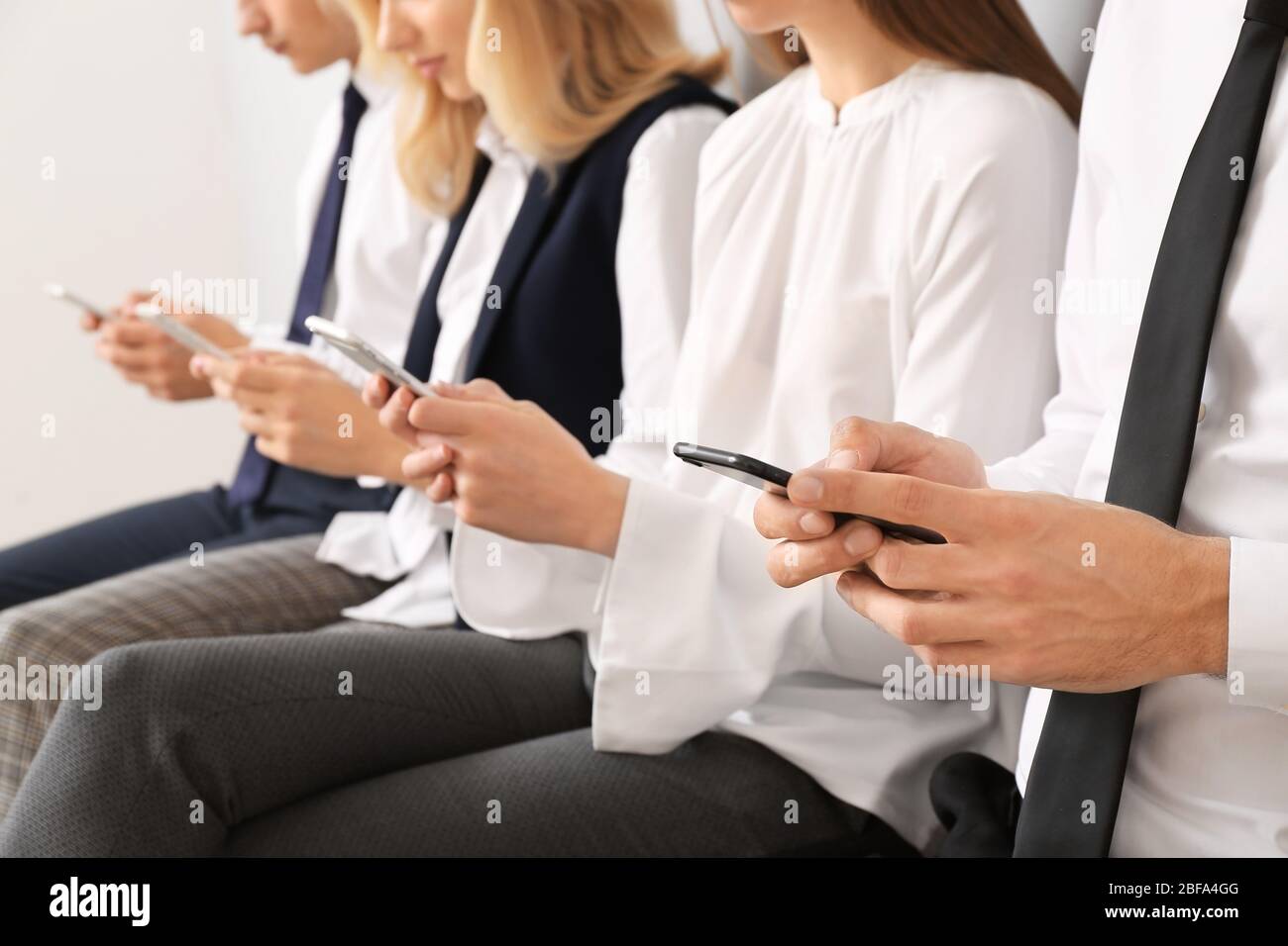 Young business people waiting in line on light background Stock Photo ...