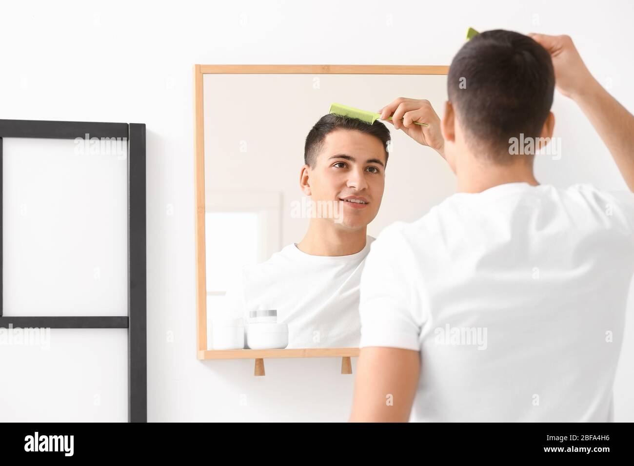 Handsome young man combing hair hi-res stock photography and images - Alamy