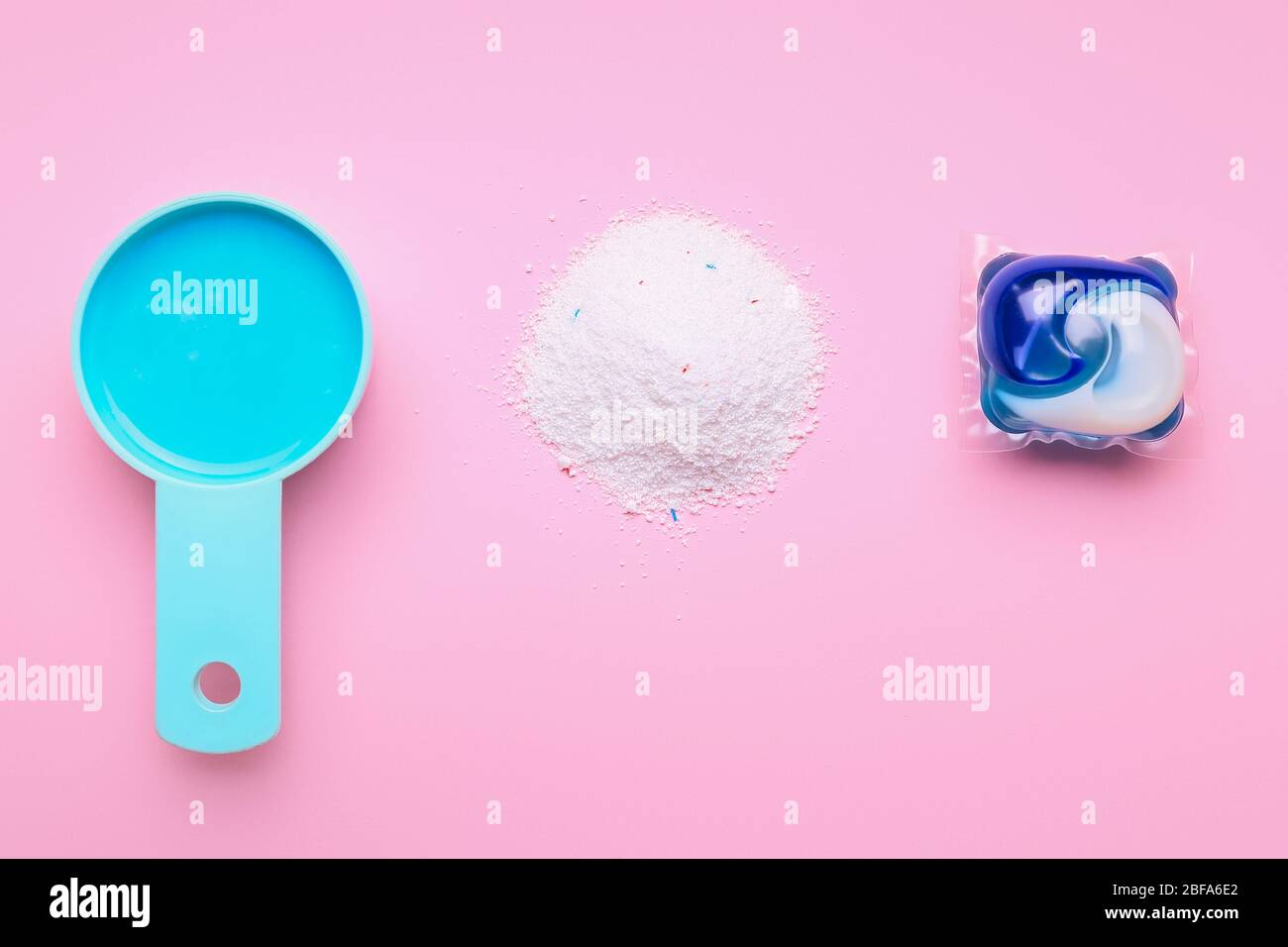 Scoop and laundry detergents on color background Stock Photo - Alamy