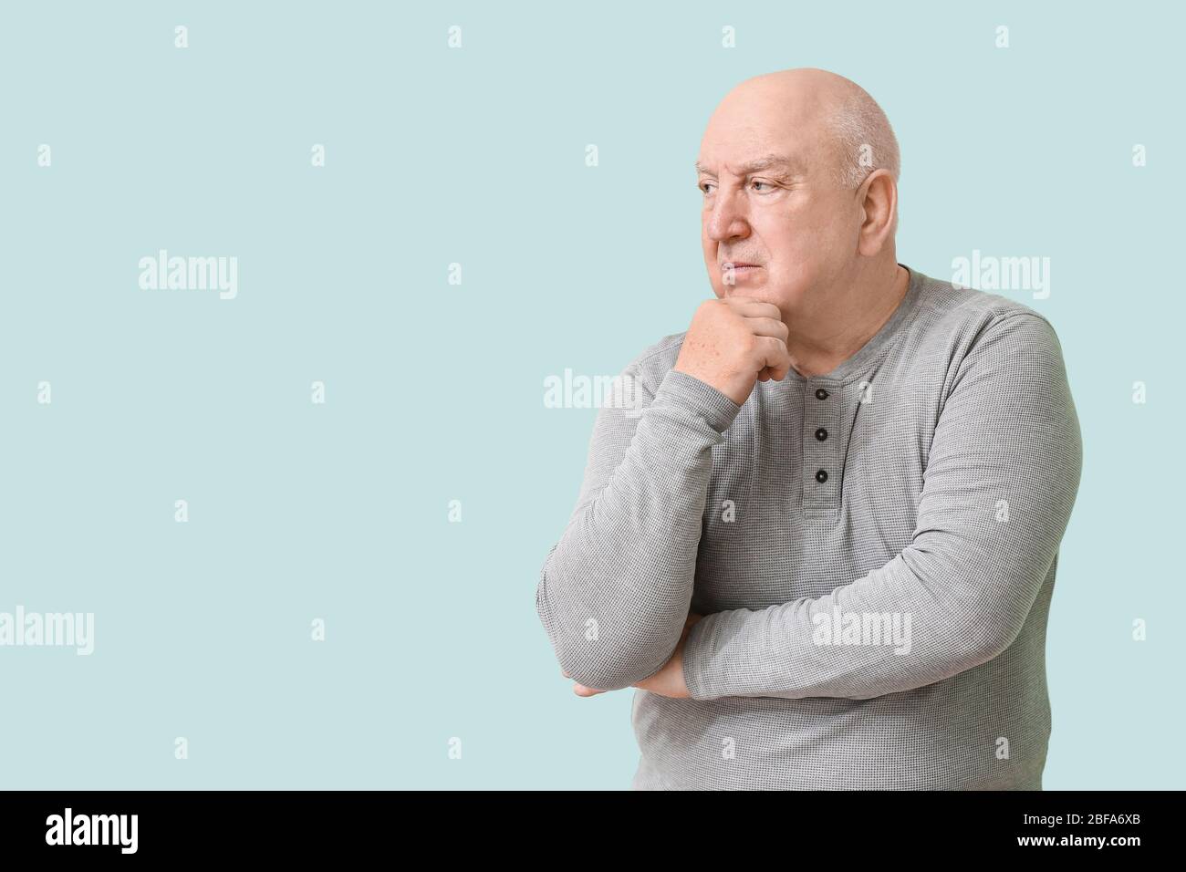 Elderly man suffering from mental disability on color background Stock ...