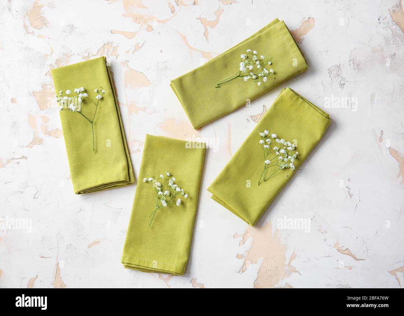 Napkins with floral decor prepared for table setting on light ...