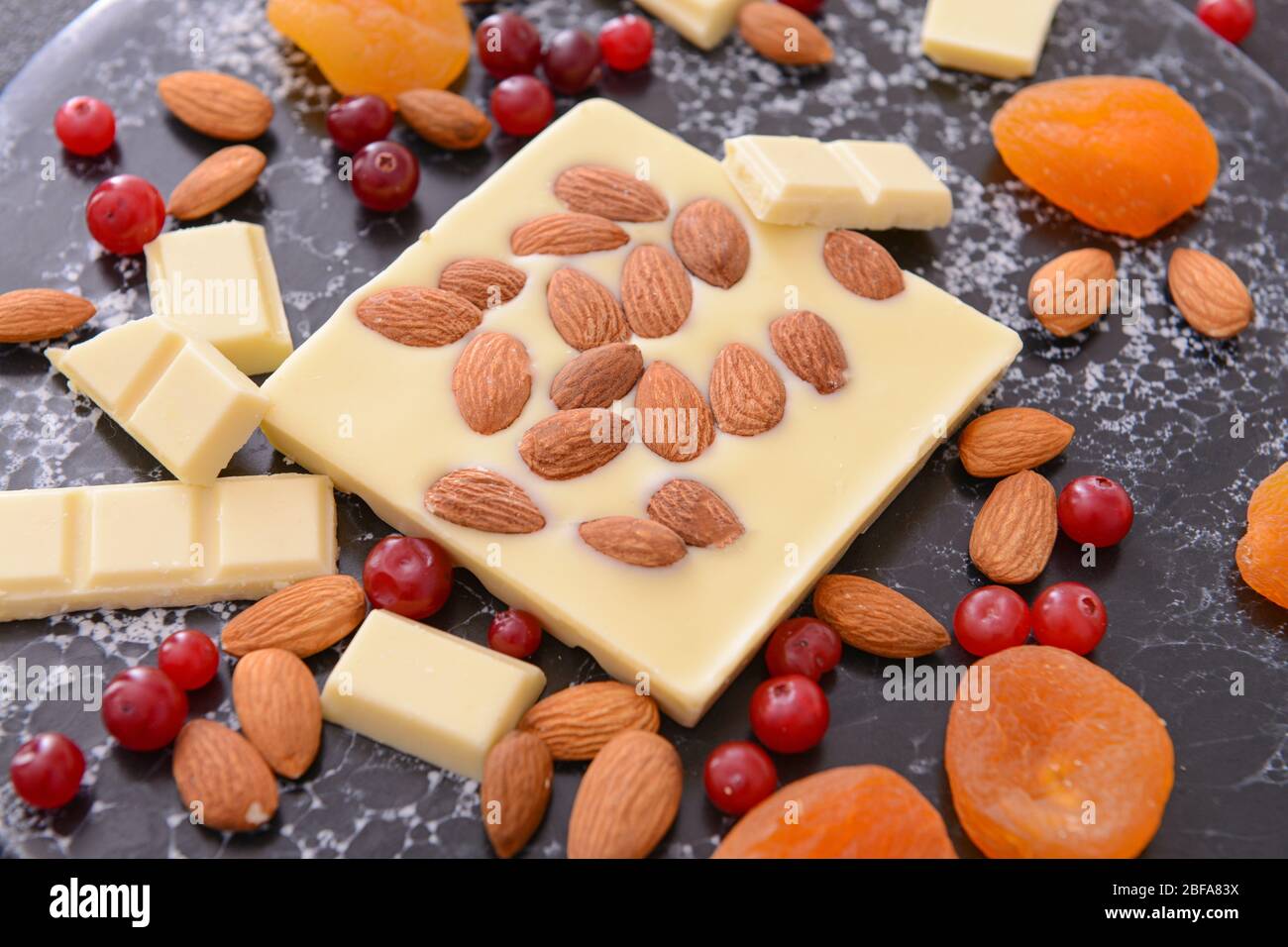 Sweet white chocolate with nuts and dried fruit on table Stock Photo ...