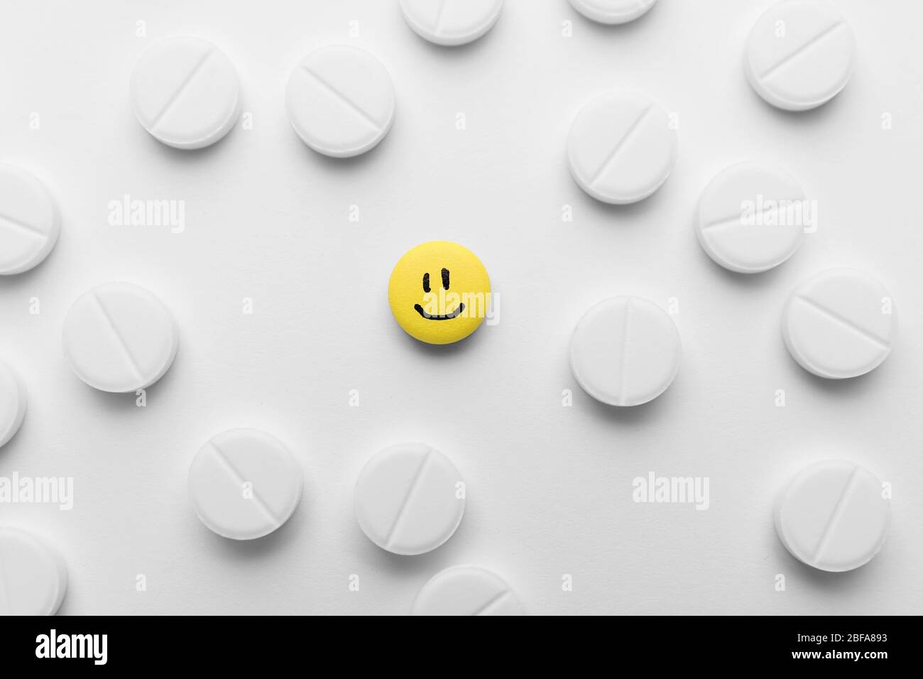 One yellow pill with drawn happy face among white ones, top view Stock ...