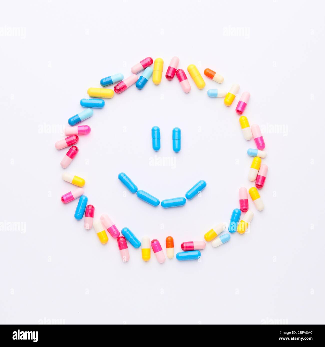 Happy face made of pills on white background Stock Photo - Alamy