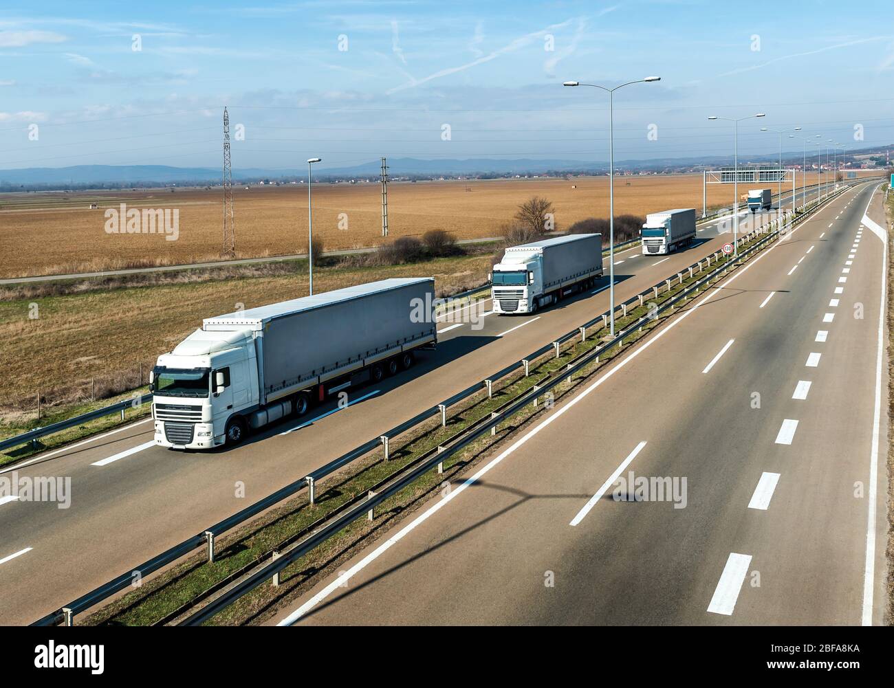 Convoy of transportation trucks in line as a caravan or convoy on a ...