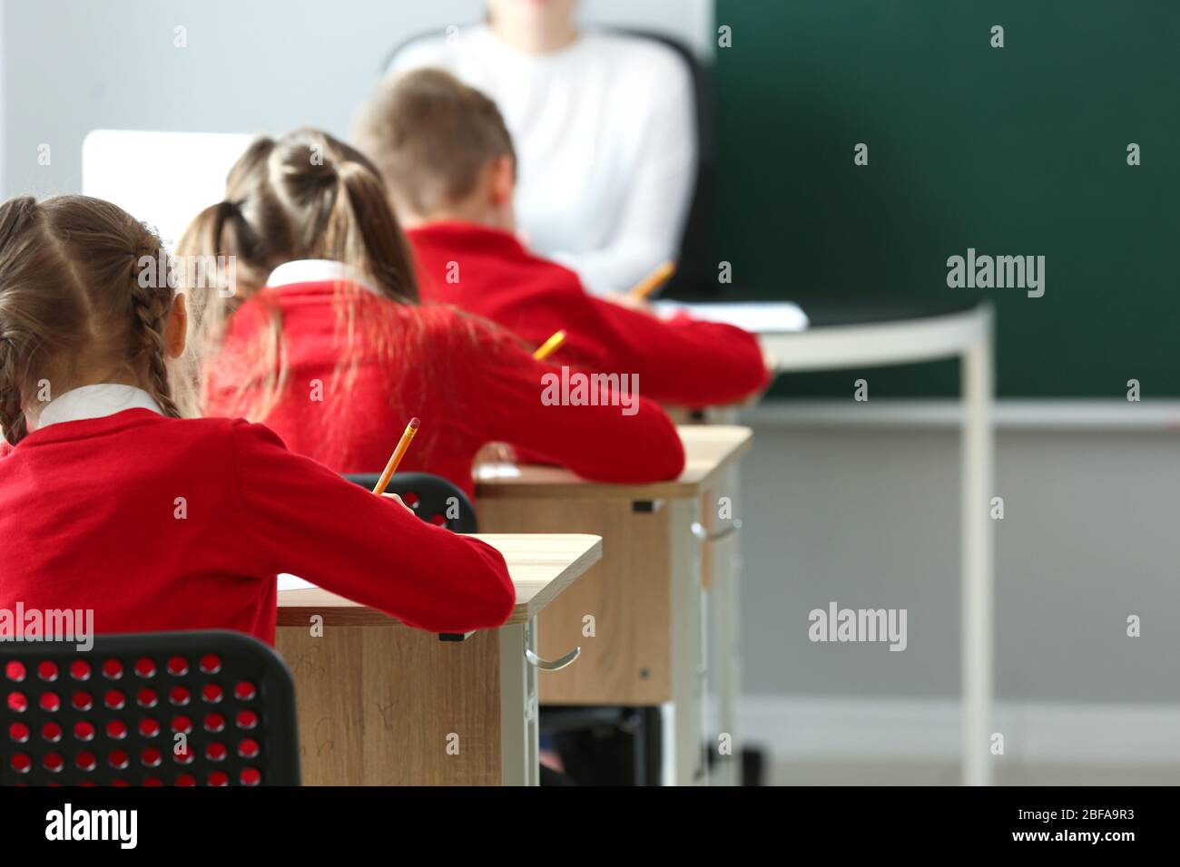 Pupils passing exam at school Stock Photo - Alamy