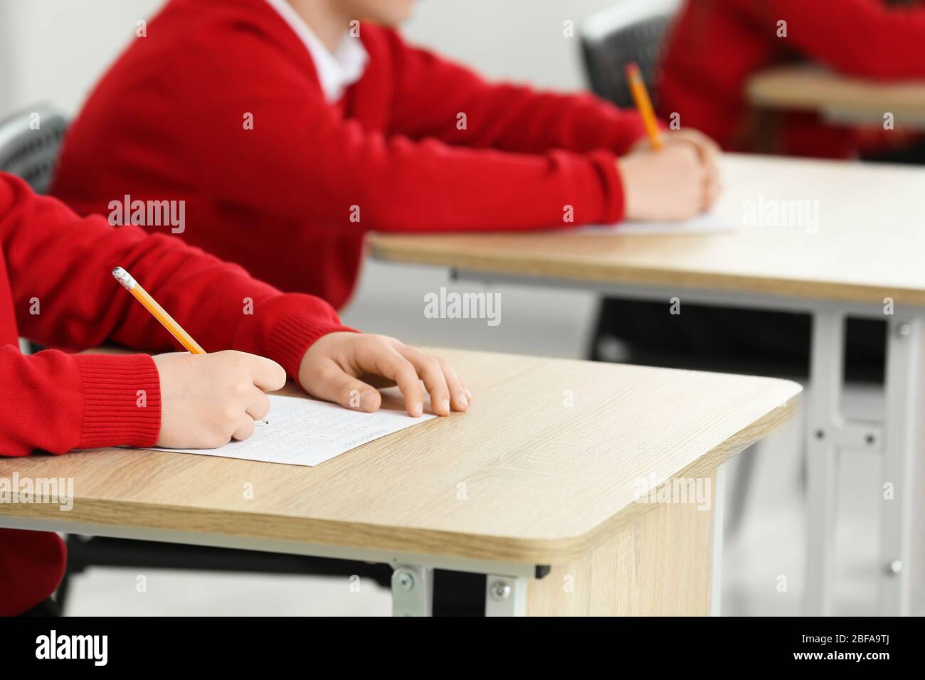 Pupils passing exam at school Stock Photo - Alamy